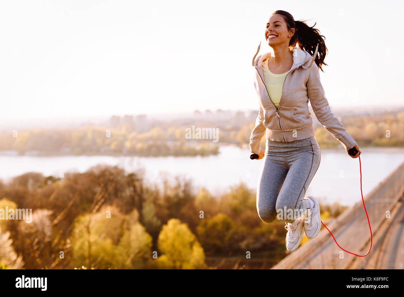 Active woman jumping with skipping rope outdoors Stock Photo - Alamy