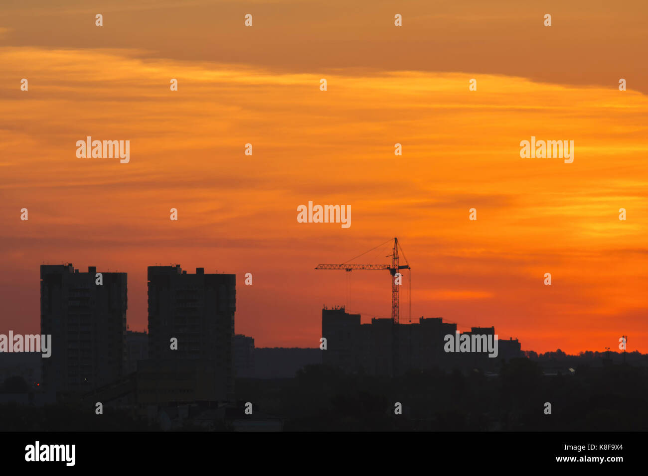 Construction cranes near residential apartments - view on sunrise ...