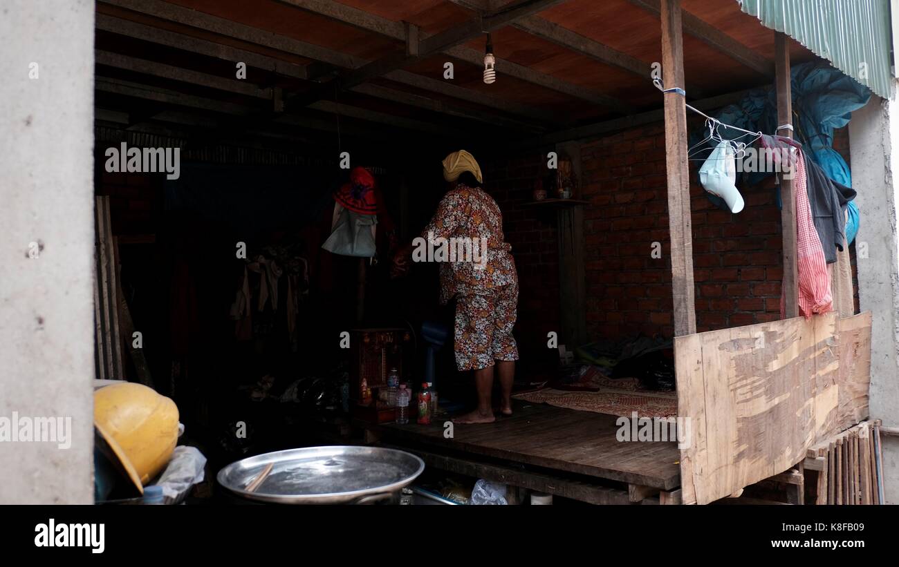 Poverty Lady dressed in pajamas in wooden Shack Bungalow in Chbar Ampov ...