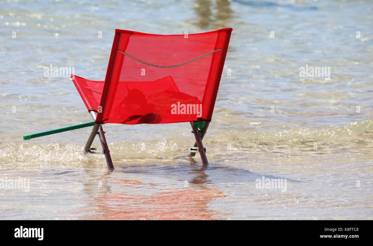 A red beach chair in the water Stock Photo - Alamy