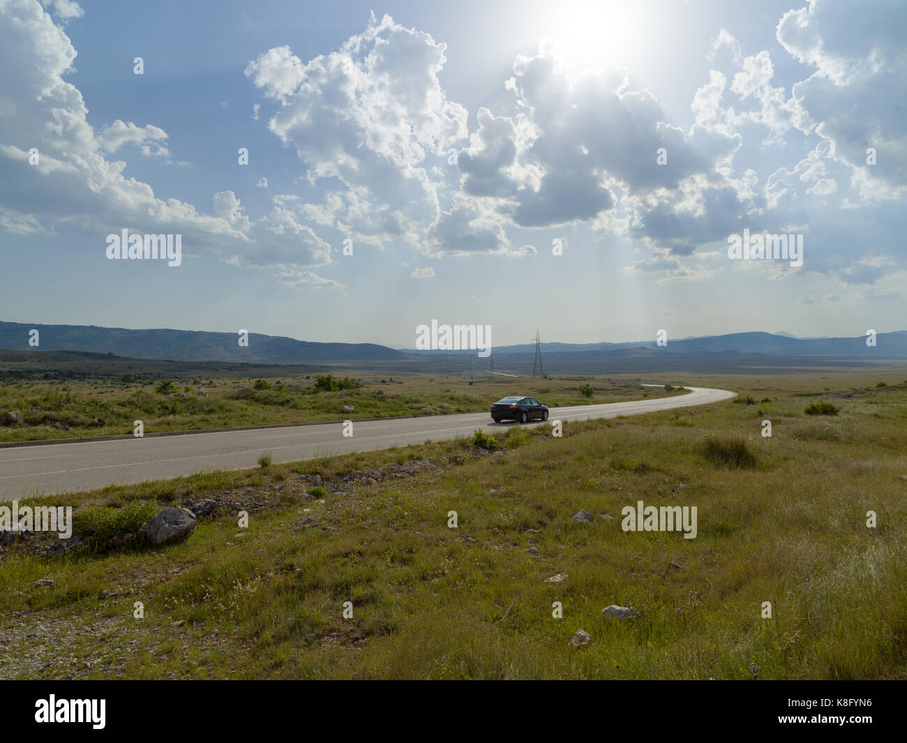 Evening summer landscape with green grass, road and clouds Stock Photo ...