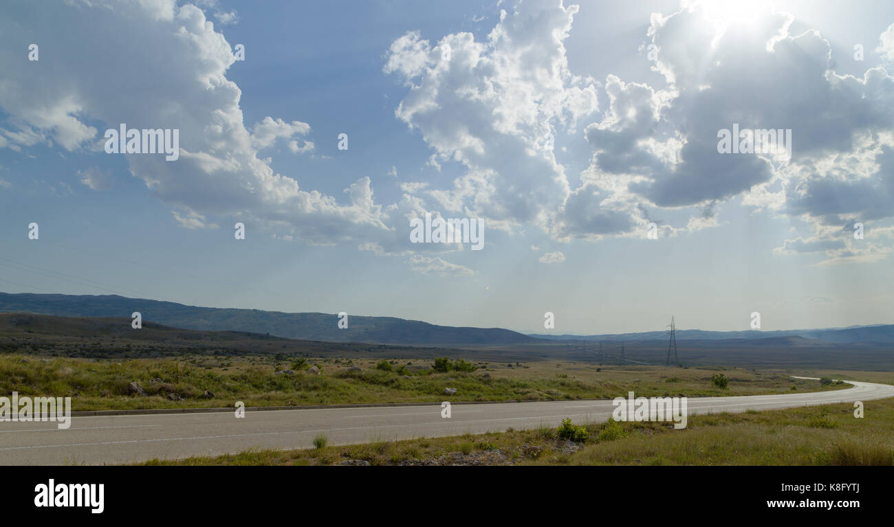 Evening summer landscape with green grass, road and clouds Stock Photo ...