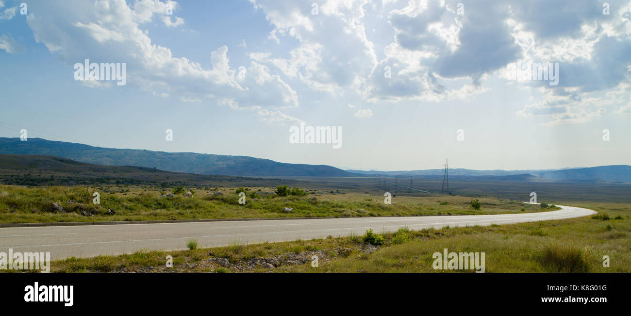 Evening summer landscape with green grass, road and clouds Stock Photo ...
