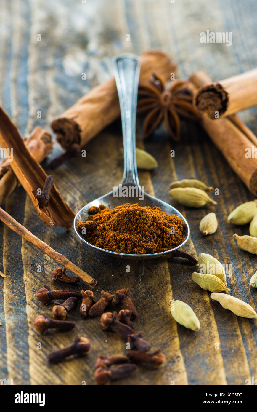 Spices - cinnamon, cloves and cardamom on wooden table - closeup with ...