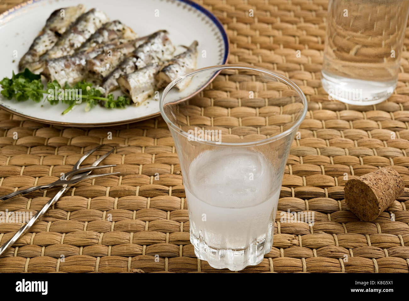 Glass and bottle of traditional drink Ouzo or Raki and appetizers on ...