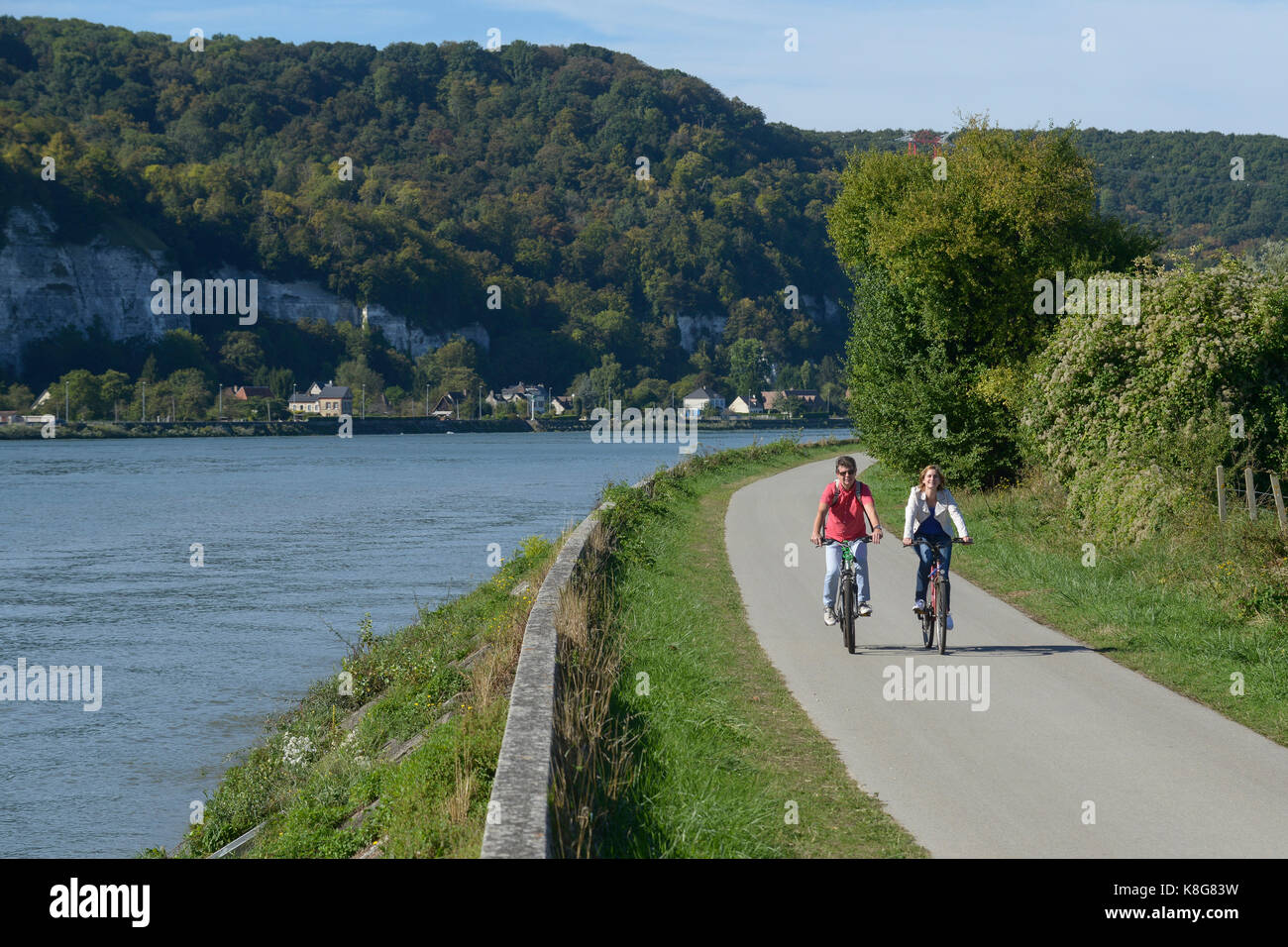 Couple of hikers riding bikes by the River Seine, on the towpath in ...