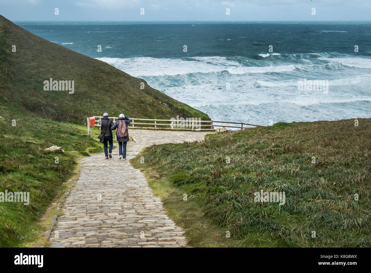 Bedruthan Steps - people walking down the coastal footpath at Bedruthan ...