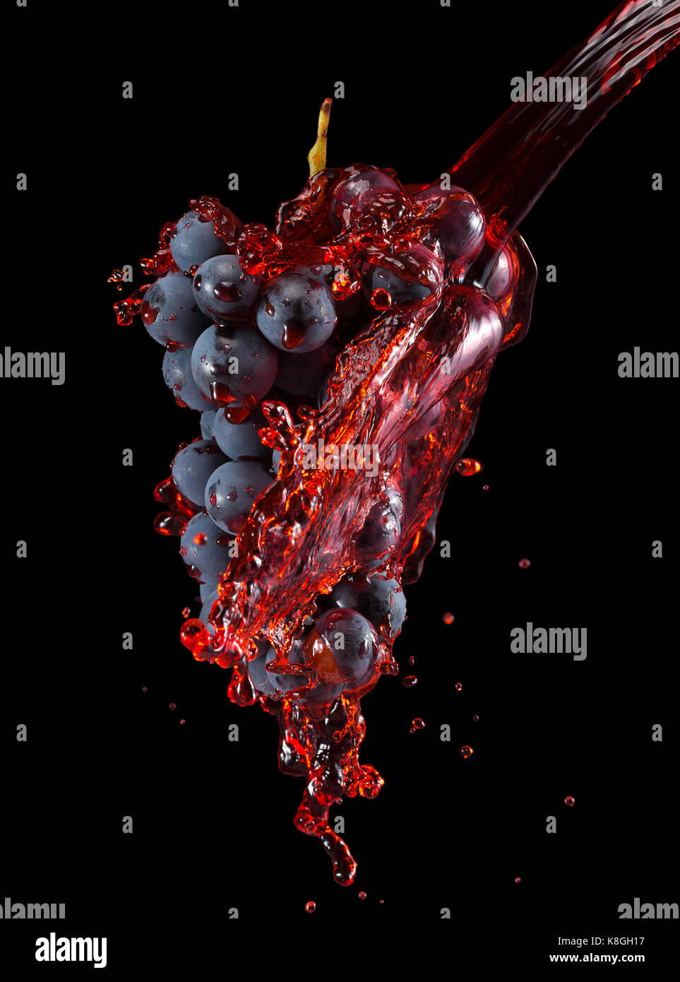 purple grapes in wine splash on a black background Stock Photo - Alamy