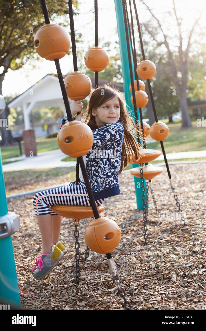 Girl playing swing in playground Stock Photo - Alamy