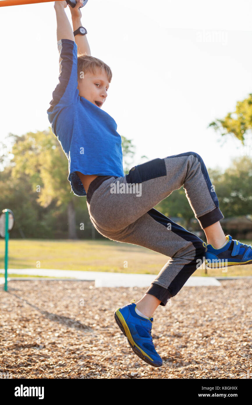 Boy hanging in playground hi-res stock photography and images - Alamy
