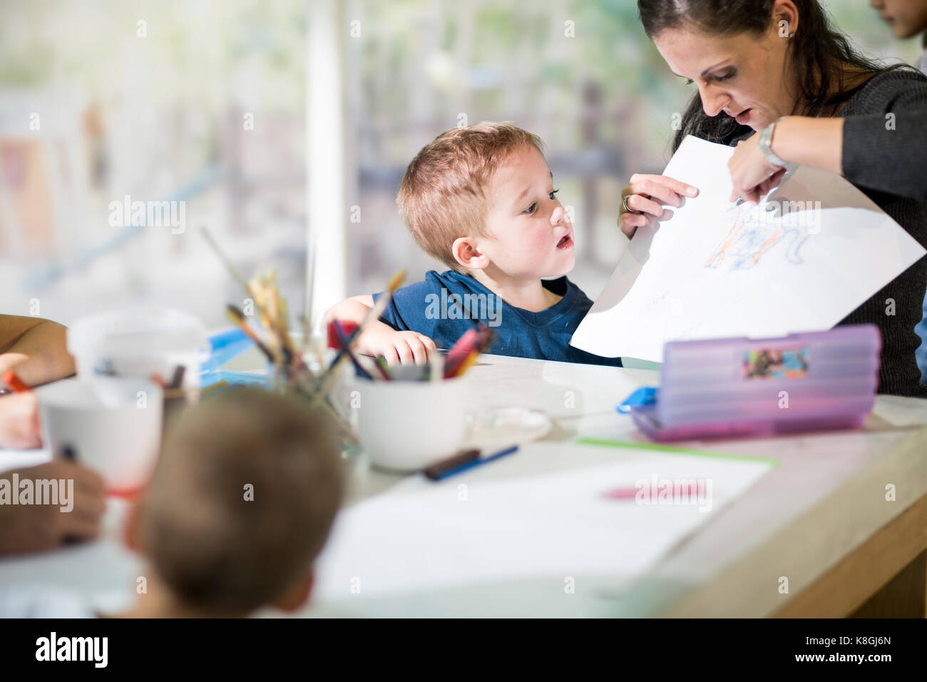 Teacher teaching boy to draw Stock Photo - Alamy