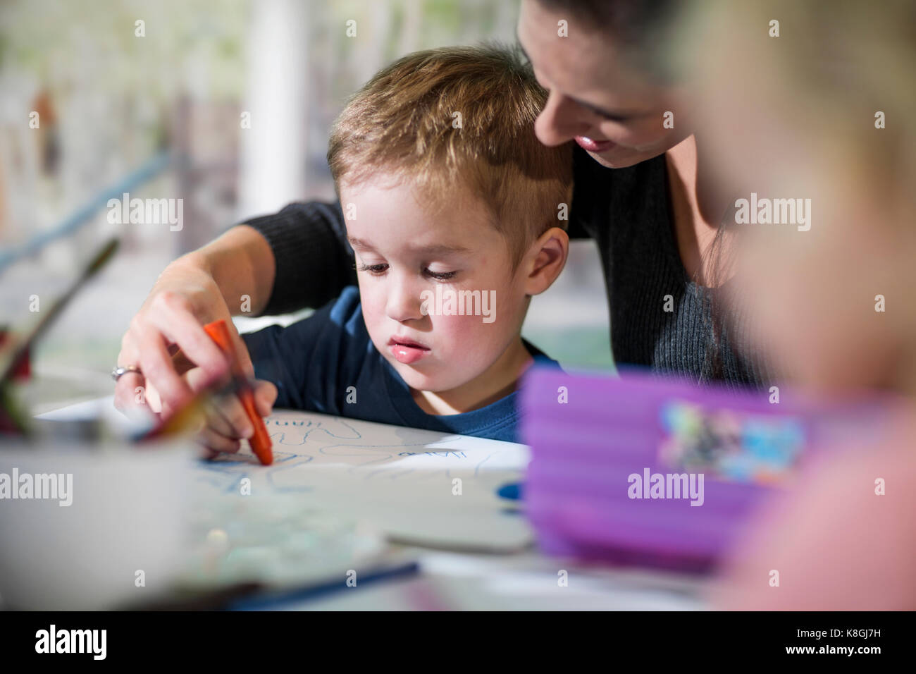 Teacher teaching boy to draw Stock Photo - Alamy