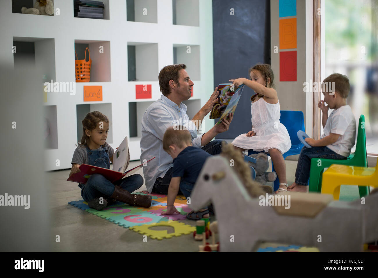 Teacher reading to children Stock Photo - Alamy