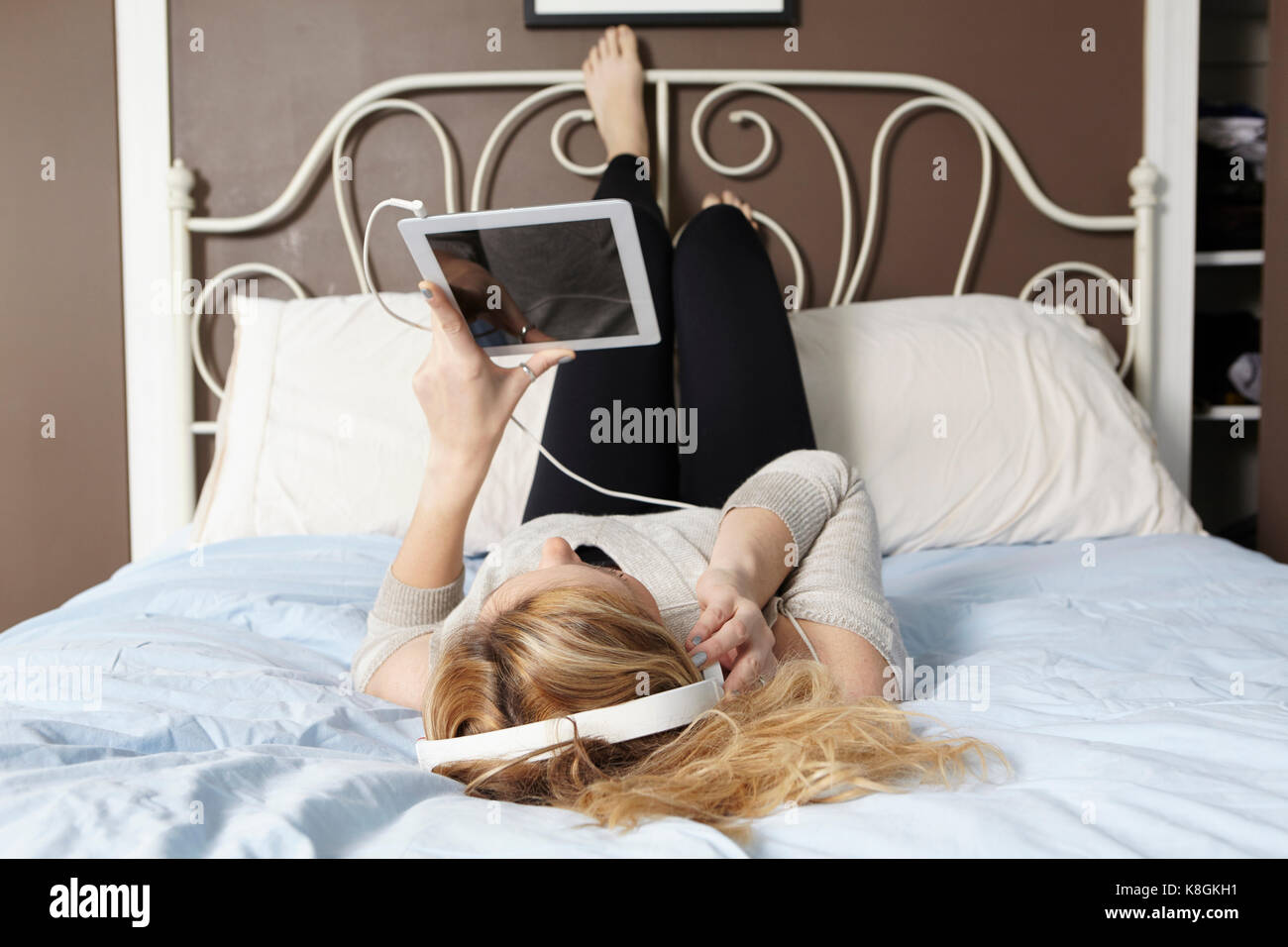 Woman using digital tablet on bed Stock Photo - Alamy