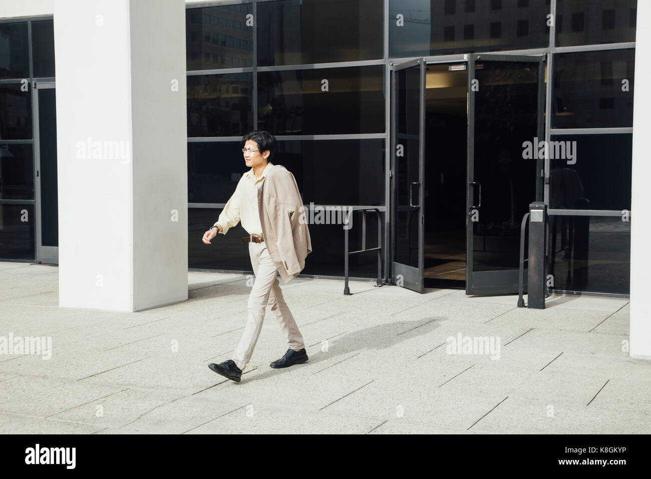 Young man exiting office building Stock Photo - Alamy