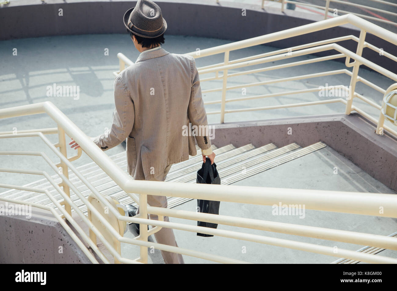 Young man outdoors, walking downstairs, rear view Stock Photo - Alamy