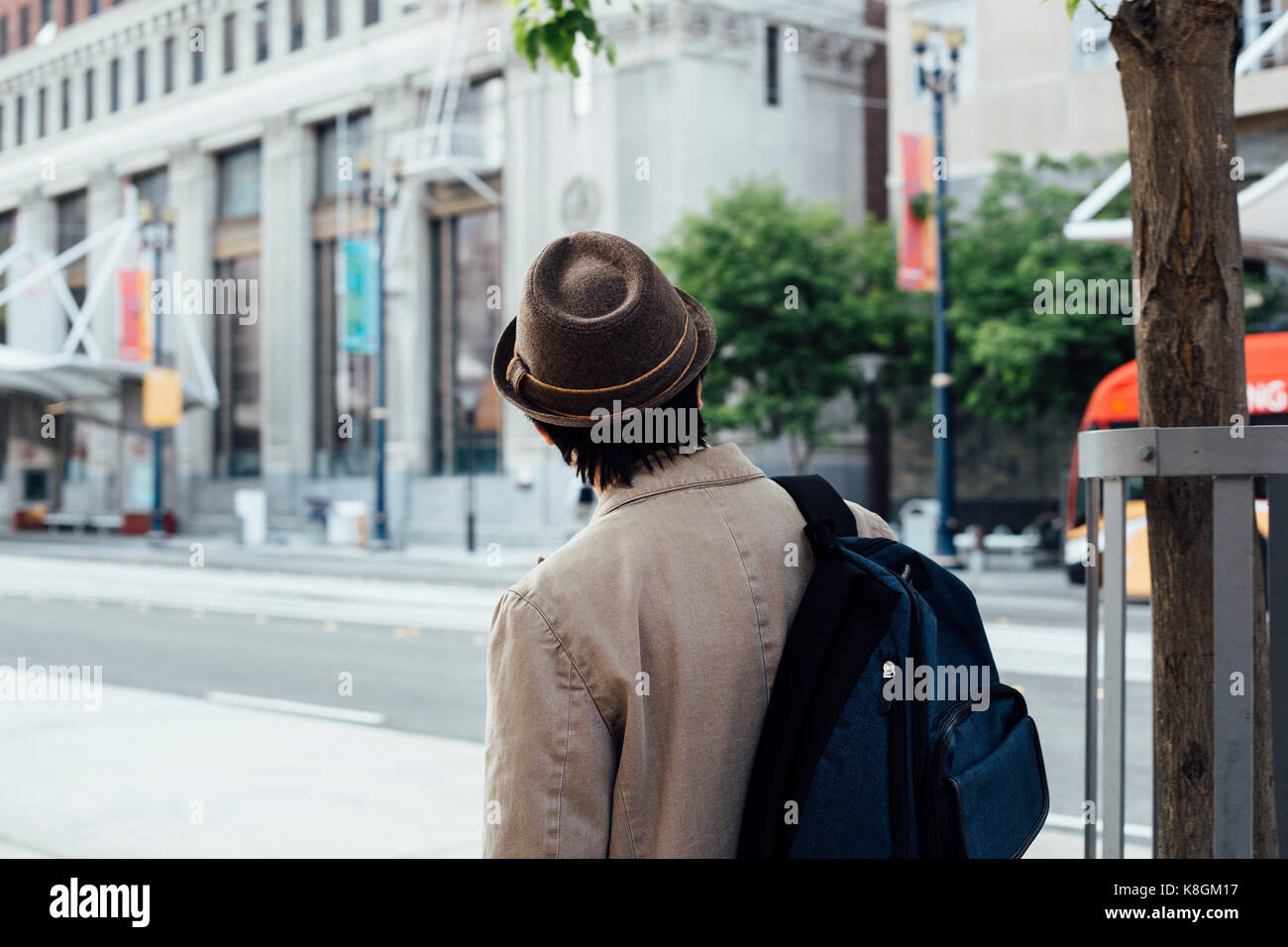 Young man walking outdoors, carrying backpack, rear view Stock Photo ...
