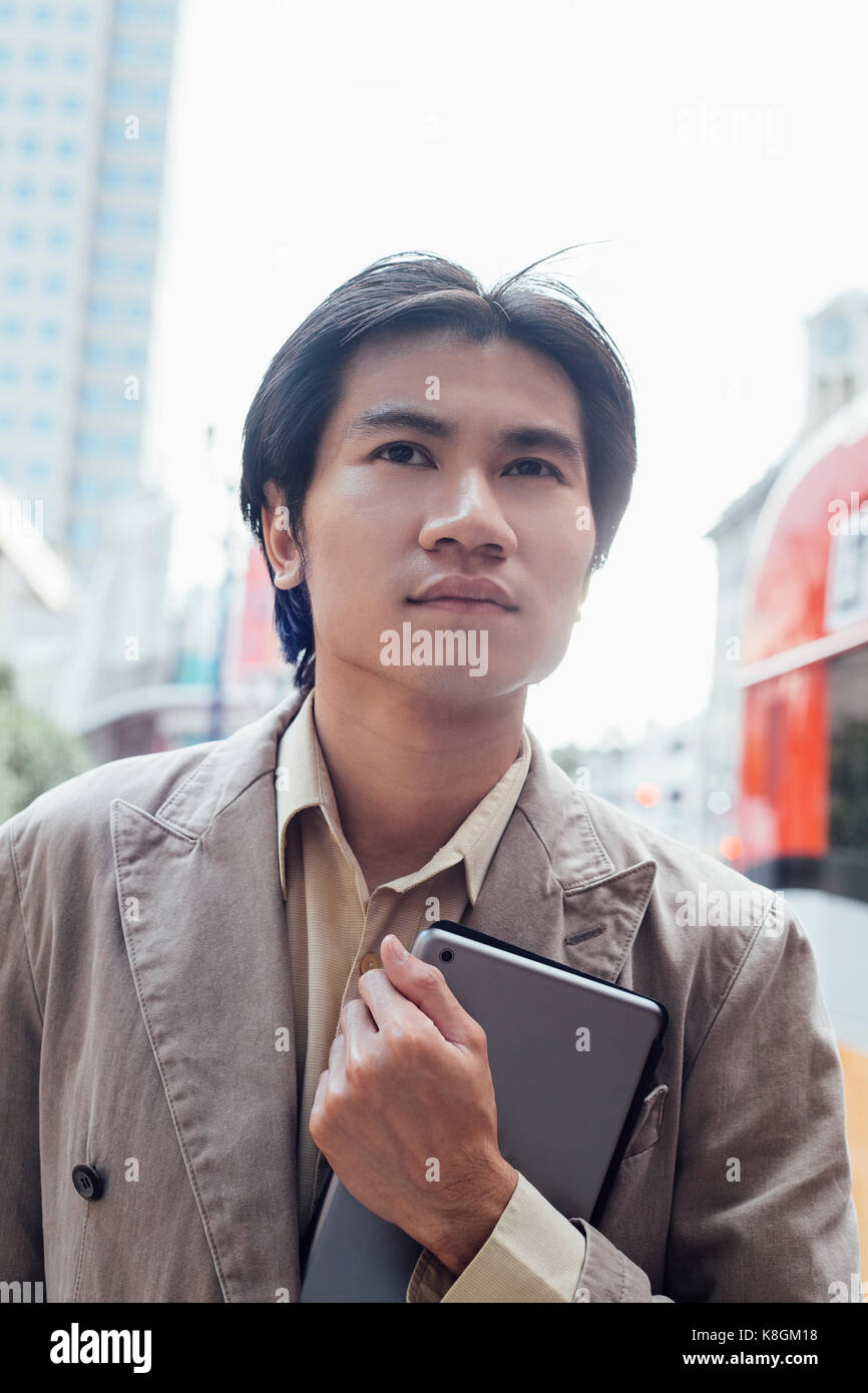 Young man walking outdoors, carrying digital tablet, close-up Stock ...
