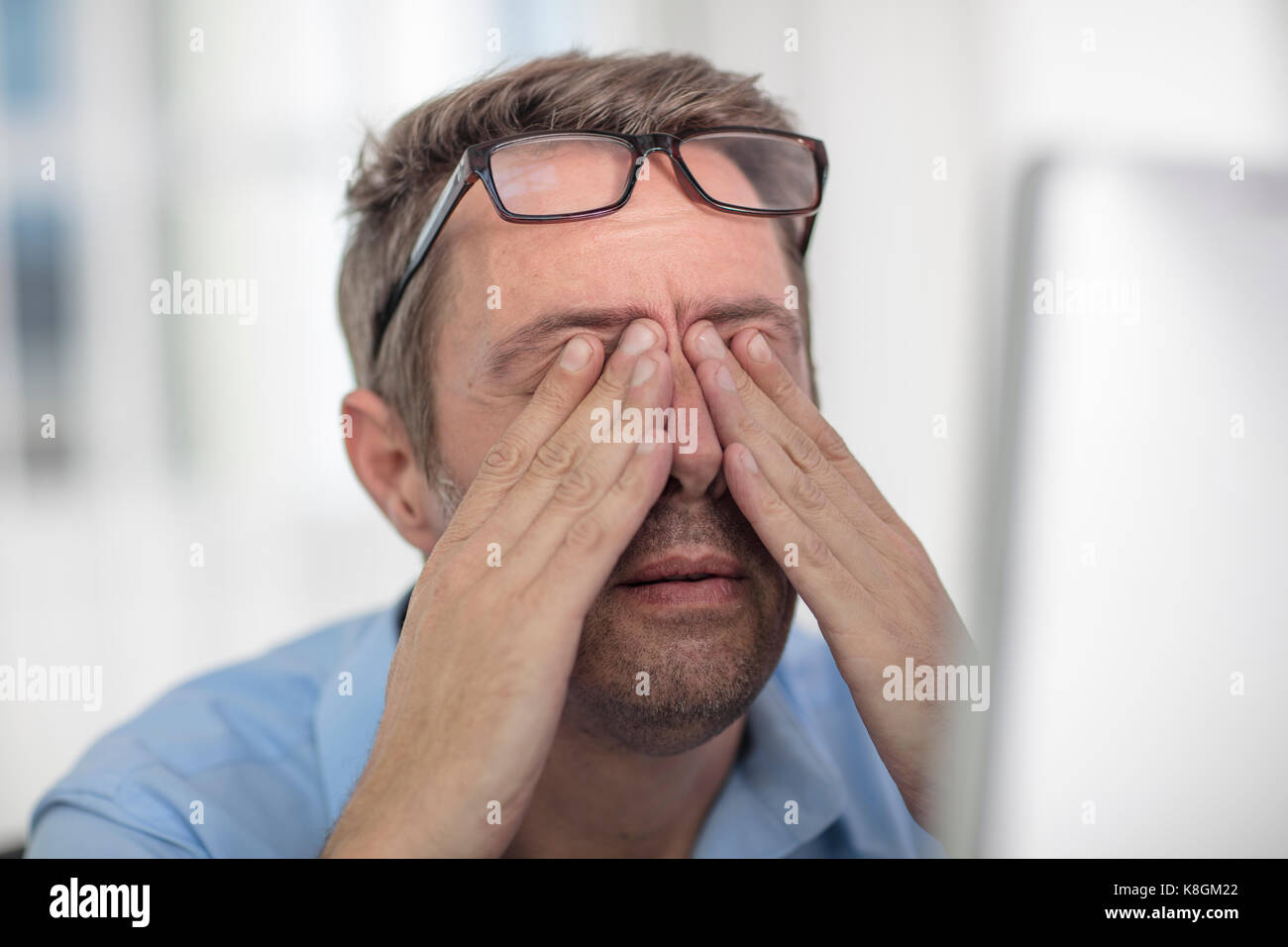 Stressed man rubbing eyes Stock Photo - Alamy