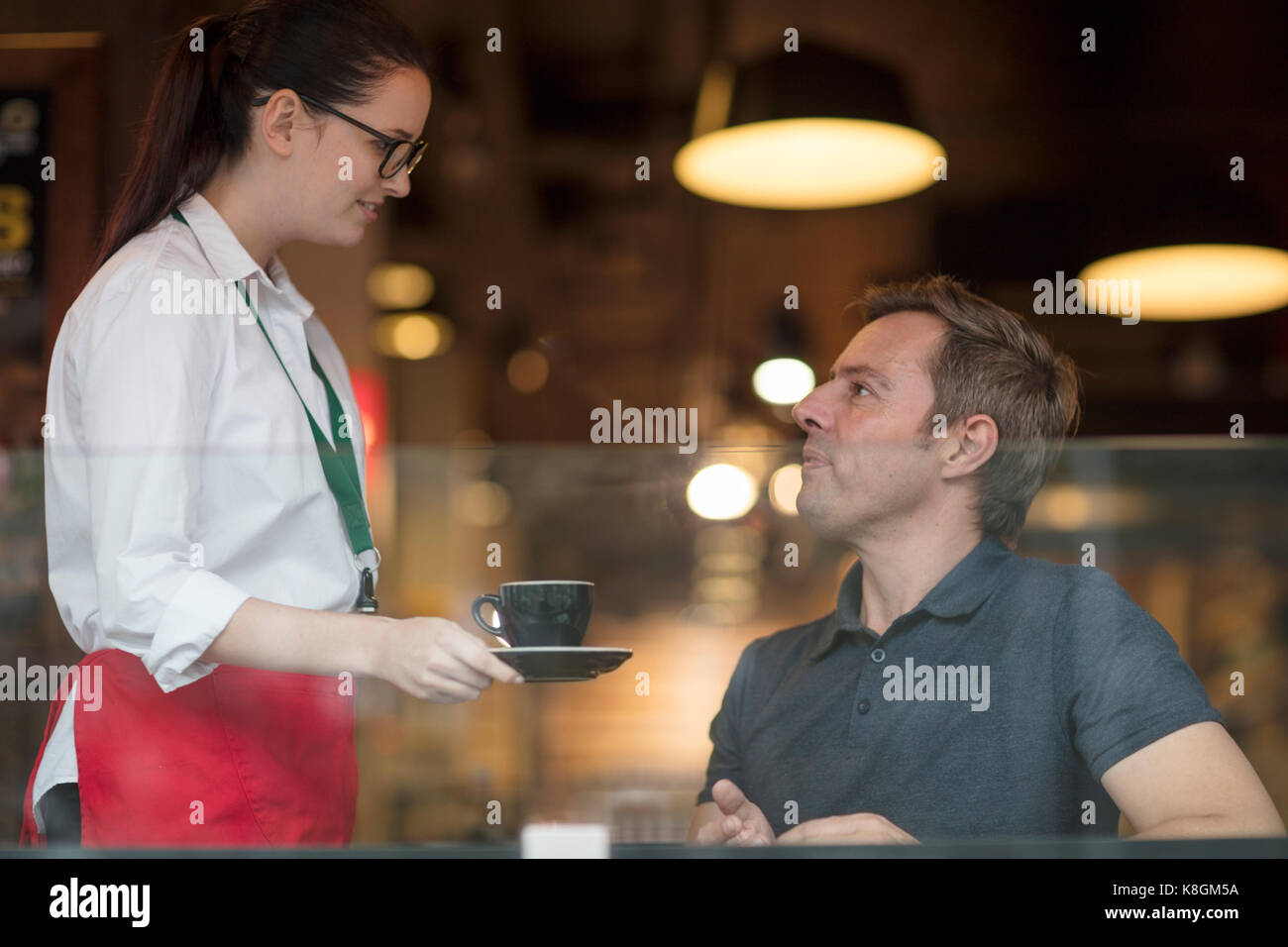 Waitress serving customer coffee Stock Photo - Alamy