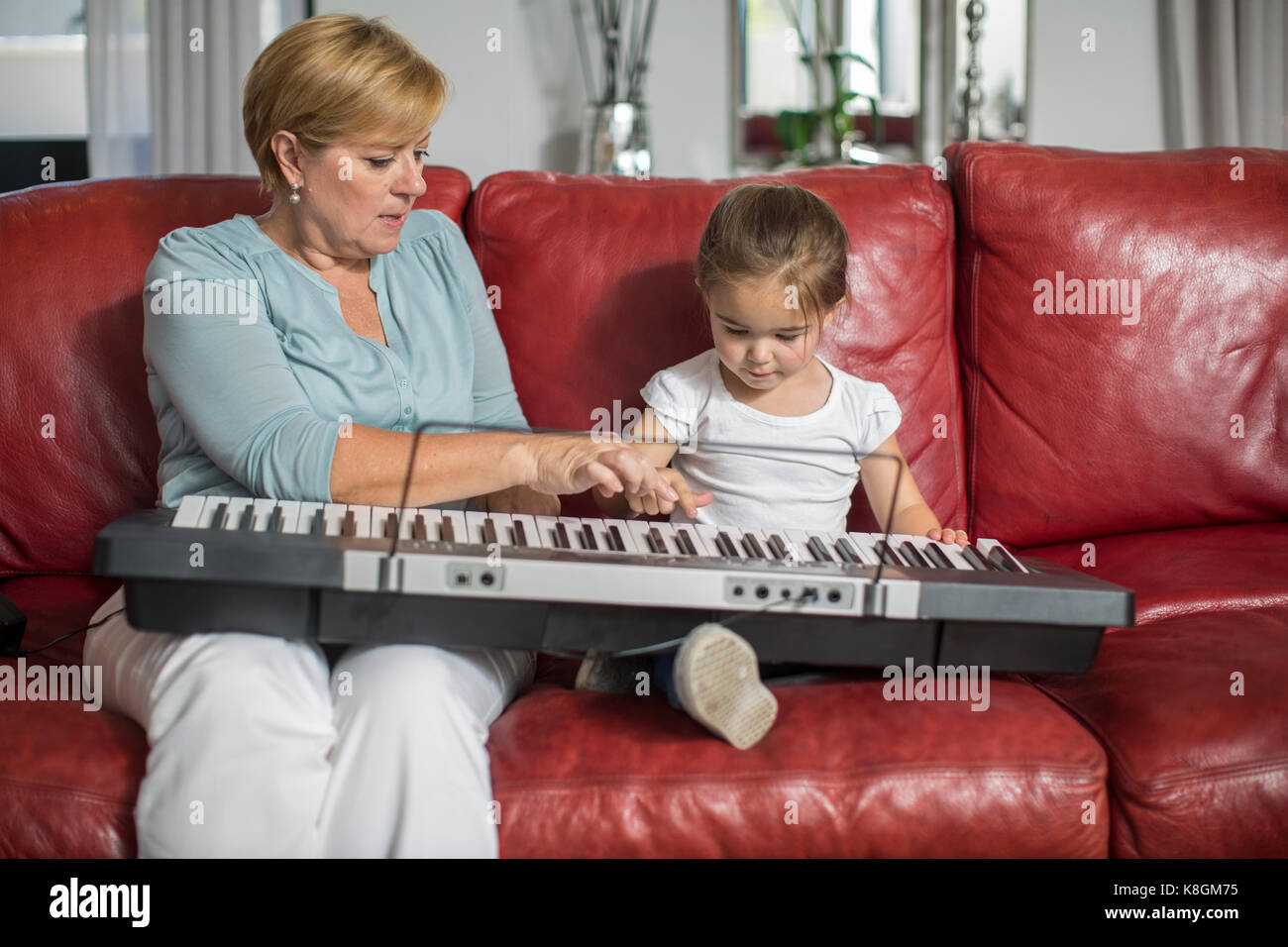 Girl and grandmother playing keyboard Stock Photo - Alamy