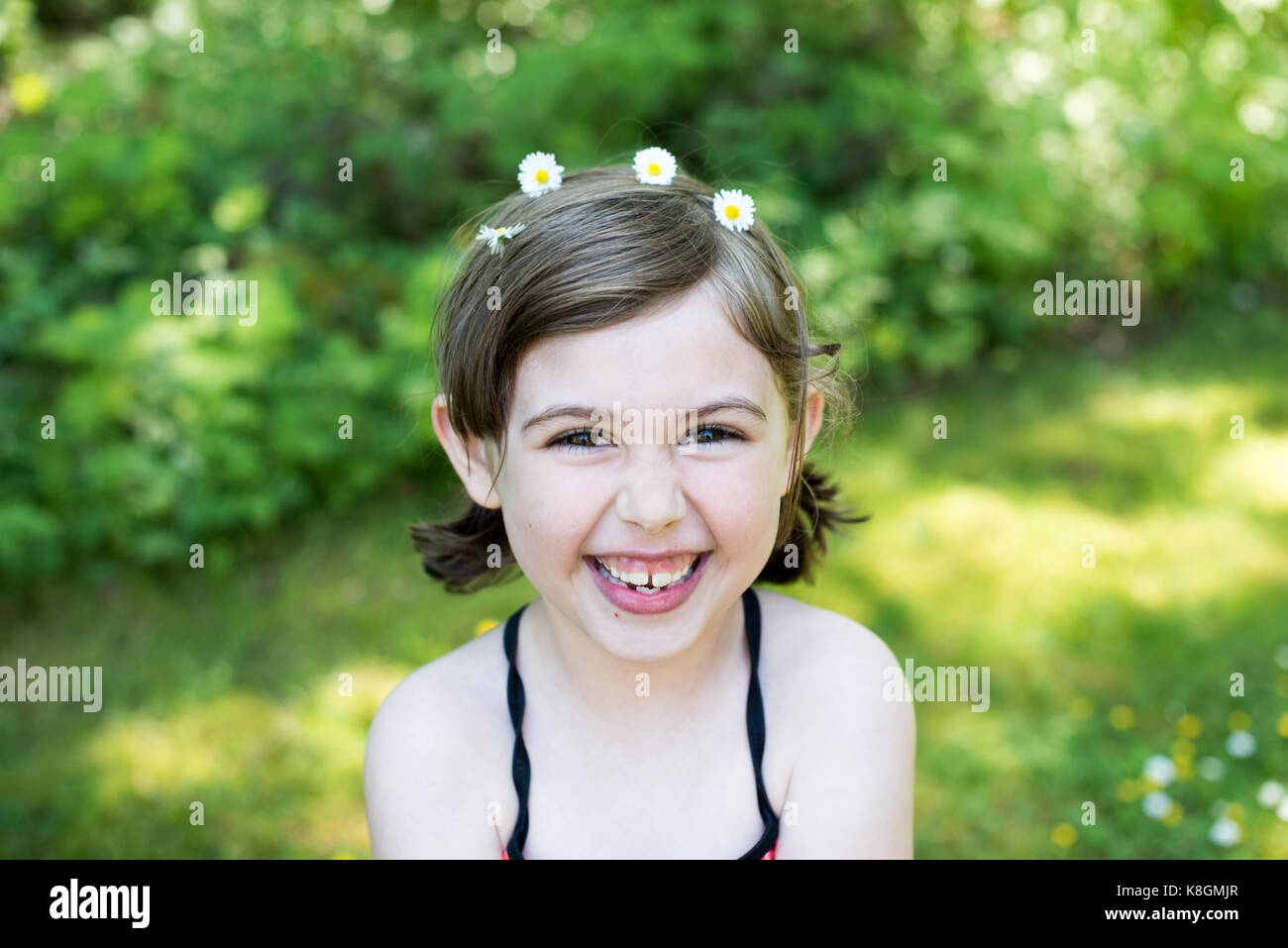 Portrait Of Young Girl Outdoors Wearing Daisies In Hair Smiling Stock