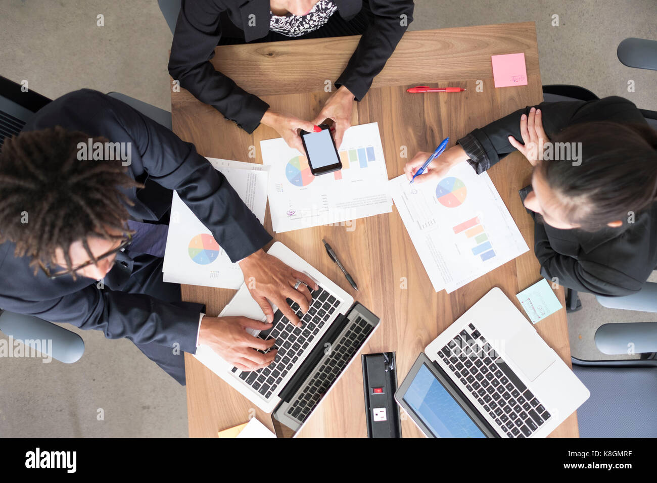 Businessman and businesswomen, in office meeting, using laptops ...
