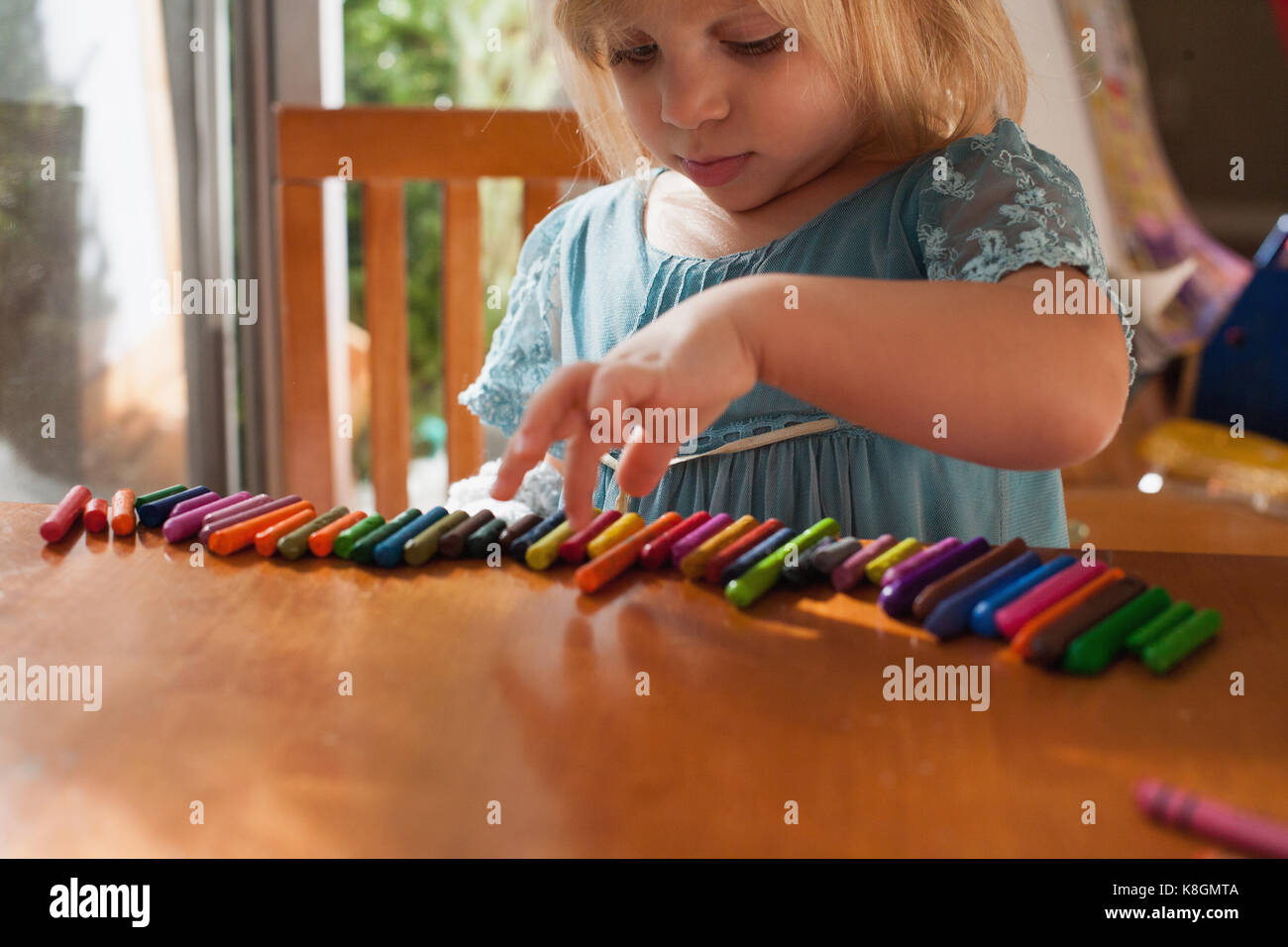 Girl lining up crayons in a row Stock Photo - Alamy