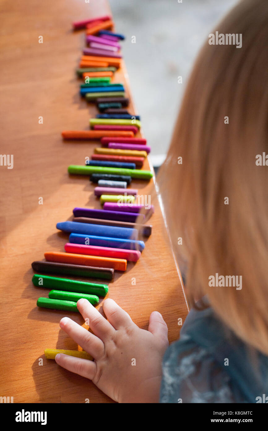 Girl lining up crayons in a row Stock Photo - Alamy