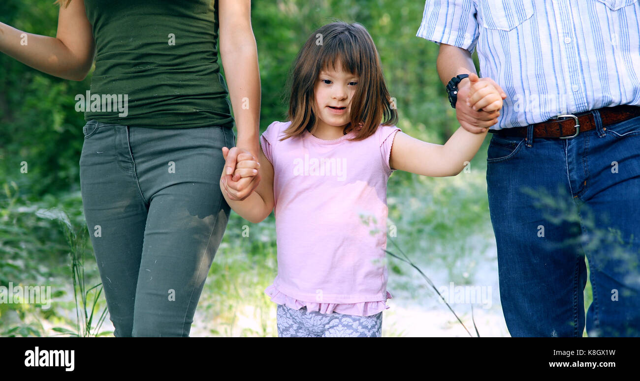 Beautiful little girl with down syndrome walking with parents Stock ...