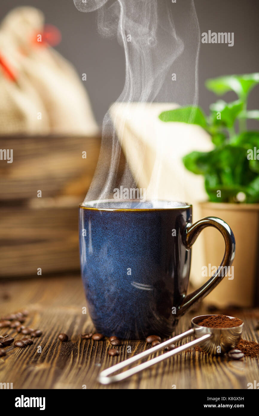 Steaming blue cup of coffee on a wooden table Stock Photo - Alamy