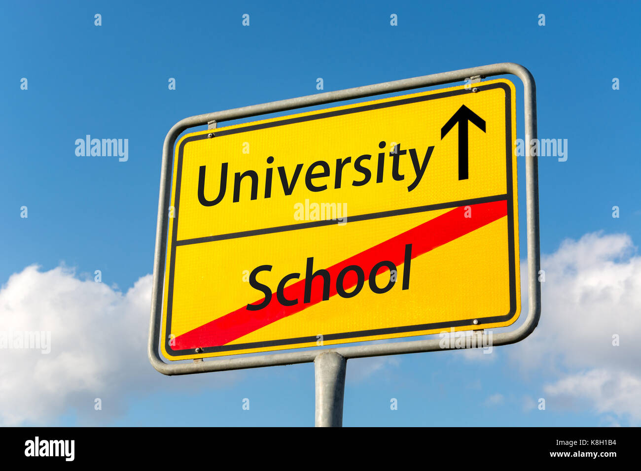 Yellow street sign with university ahead leaving school behind close up ...