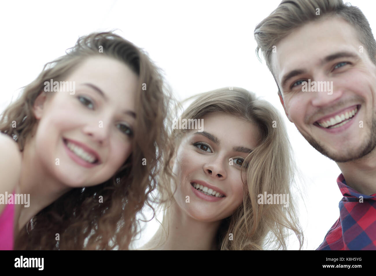 closeup of three young people smiling on white background Stock Photo ...