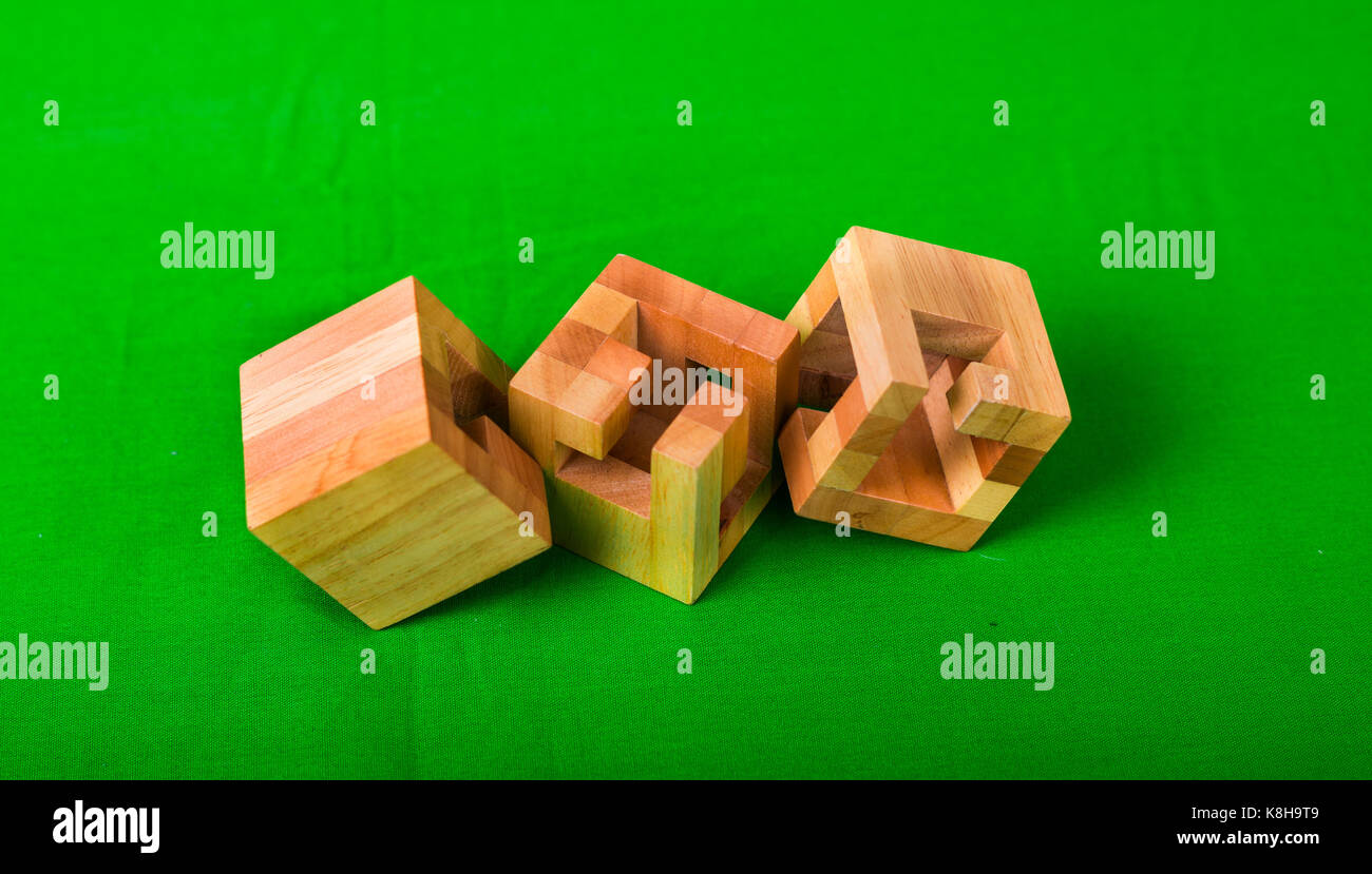 Wooden Brain Teaser or Wooden Puzzles on green background Stock Photo ...