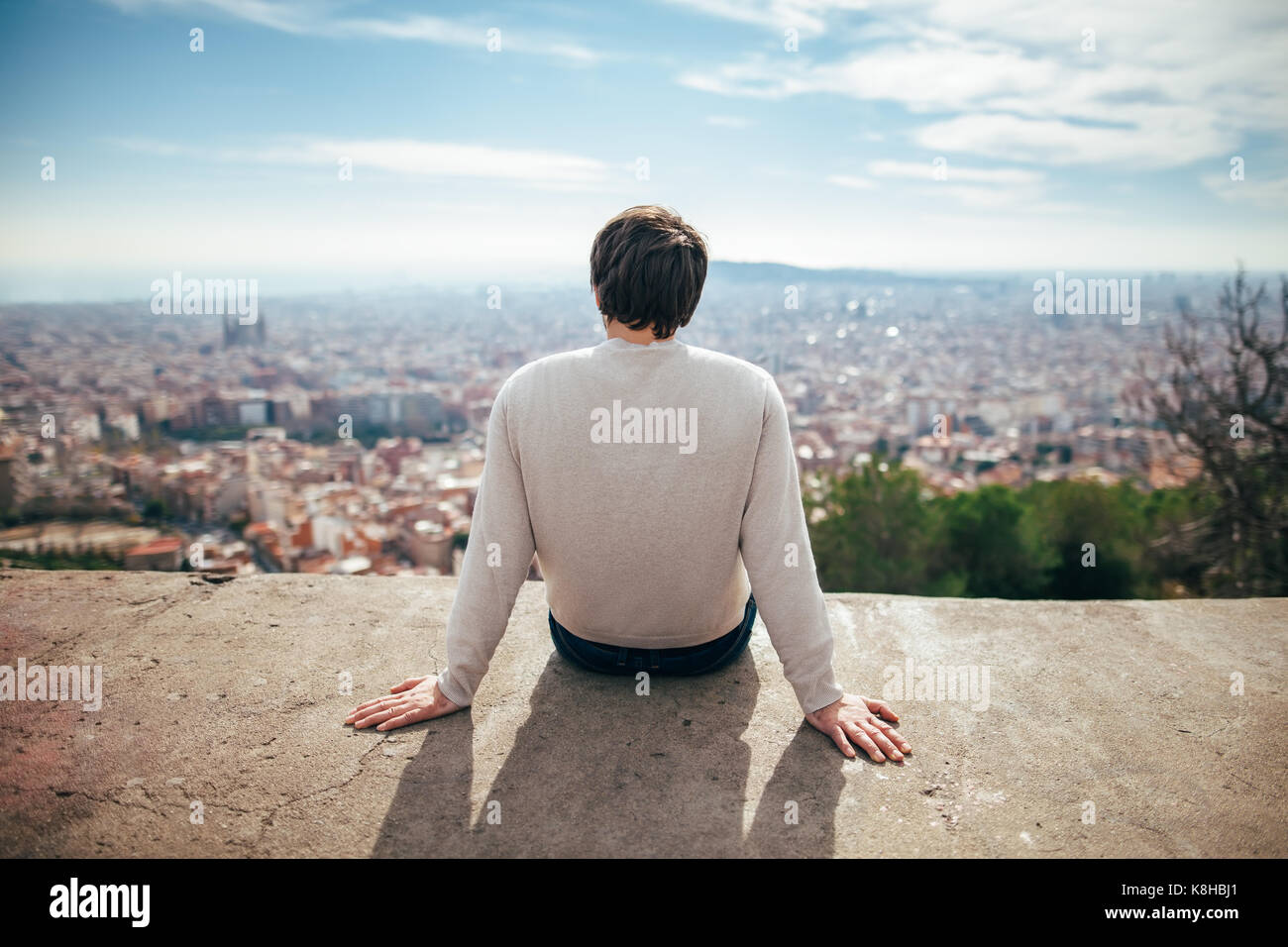 Back view of young man enjoying Barcelona city view from Bunkers del ...