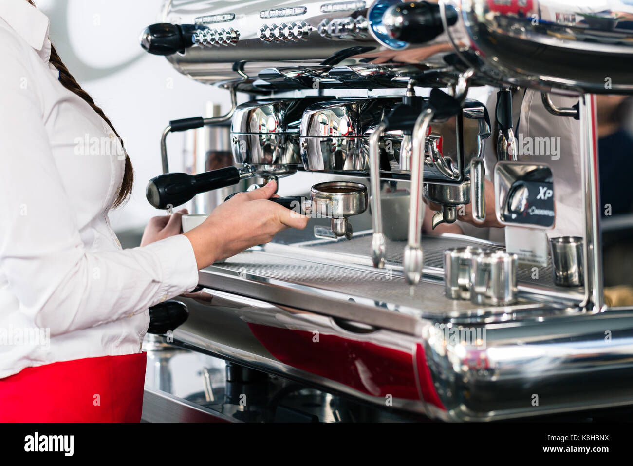 Close-up of female hand on the portafilter of an automatic coffe Stock ...
