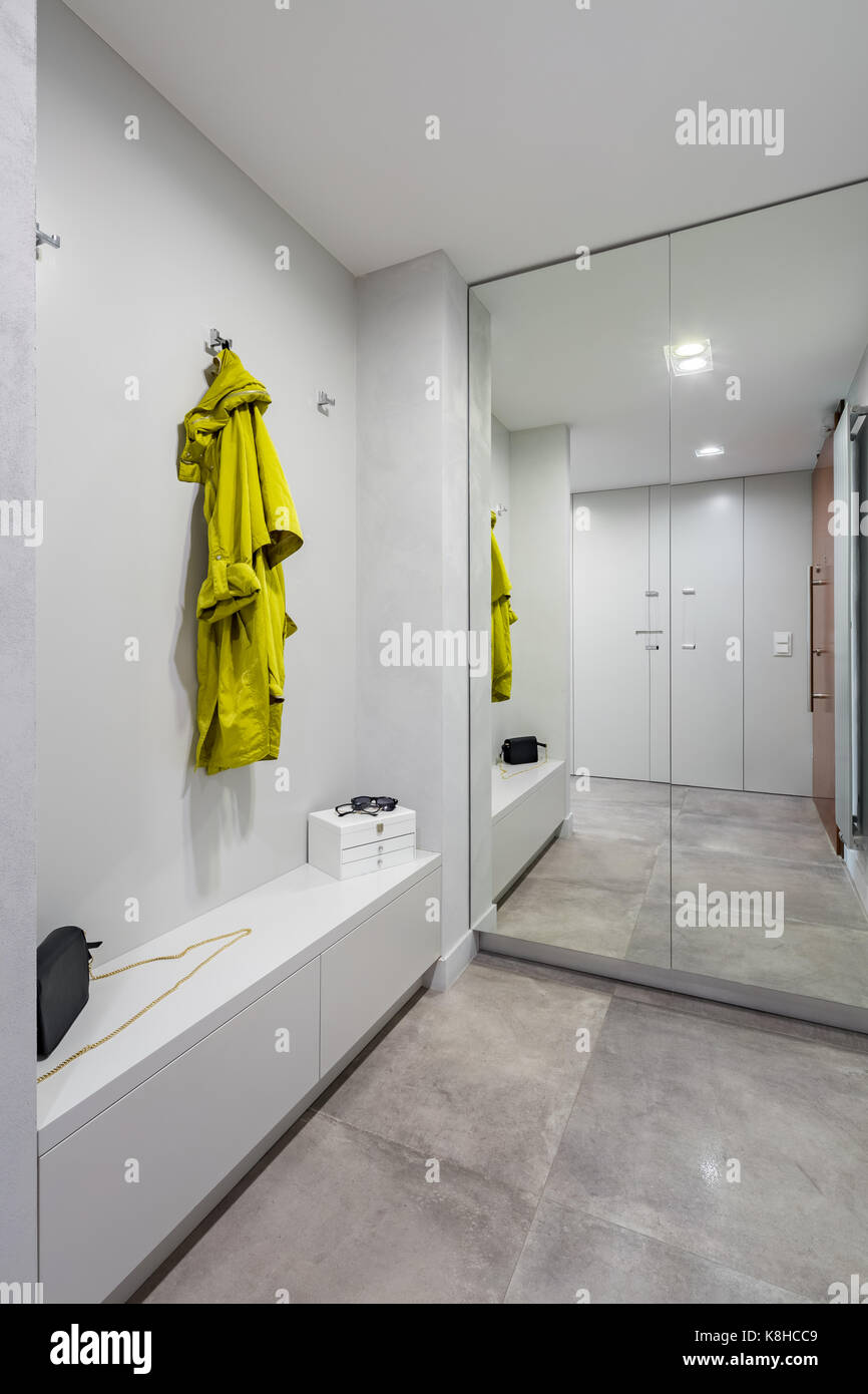 Entryway with modern mirrored wardrobe and white storage bench Stock ...
