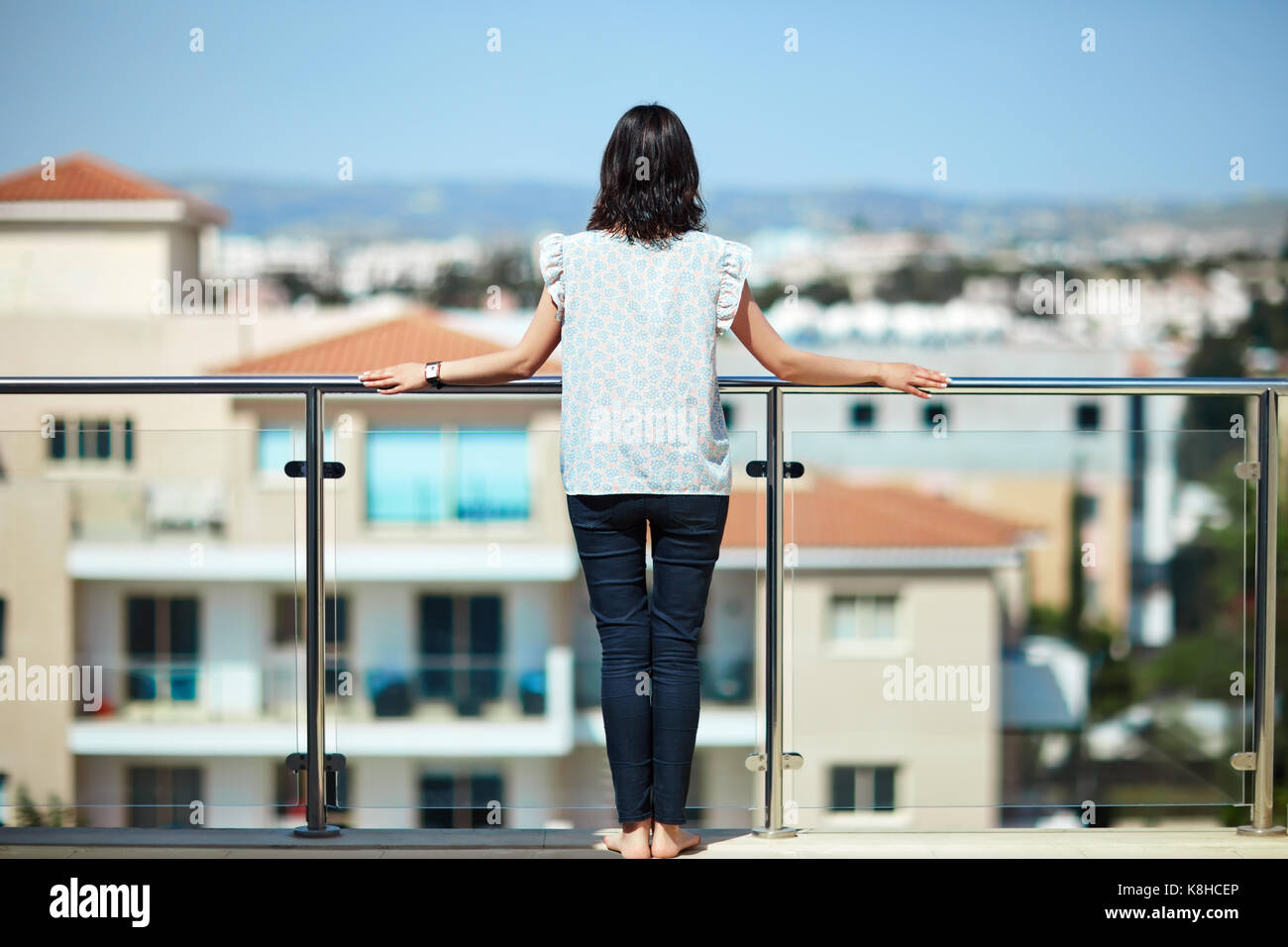 Beautiful woman enjoying cityscape standing on rooftop Stock Photo - Alamy