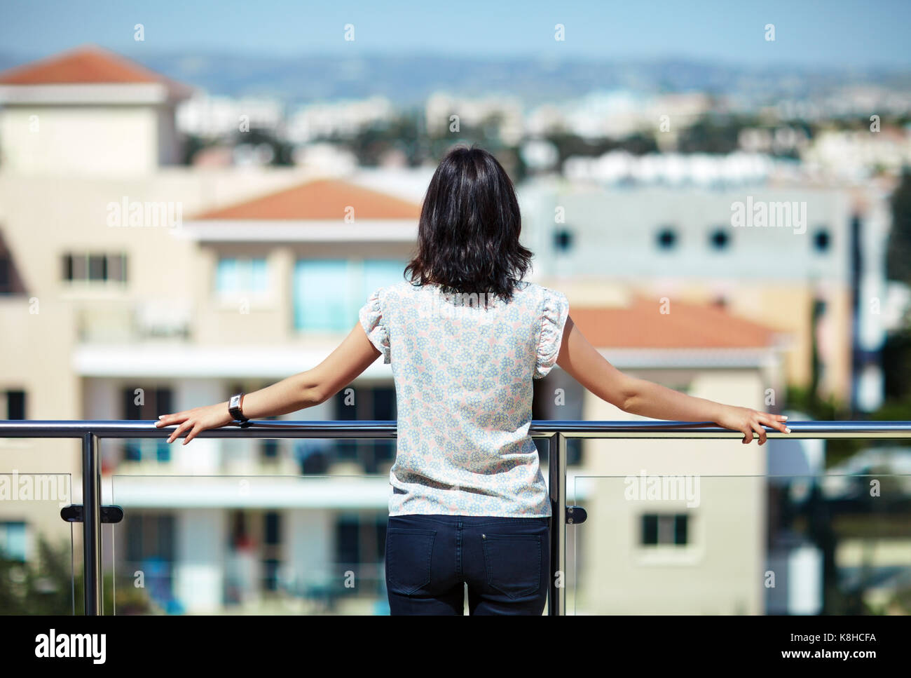 Beautiful woman enjoying cityscape standing on rooftop Stock Photo - Alamy