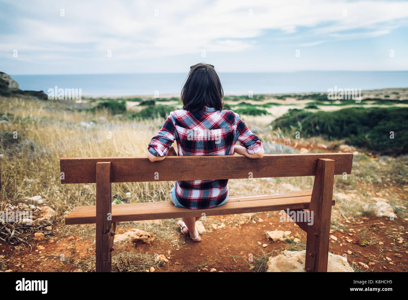 Woman enjoying sea view sitting on a bench in beautiful valley. Relax ...
