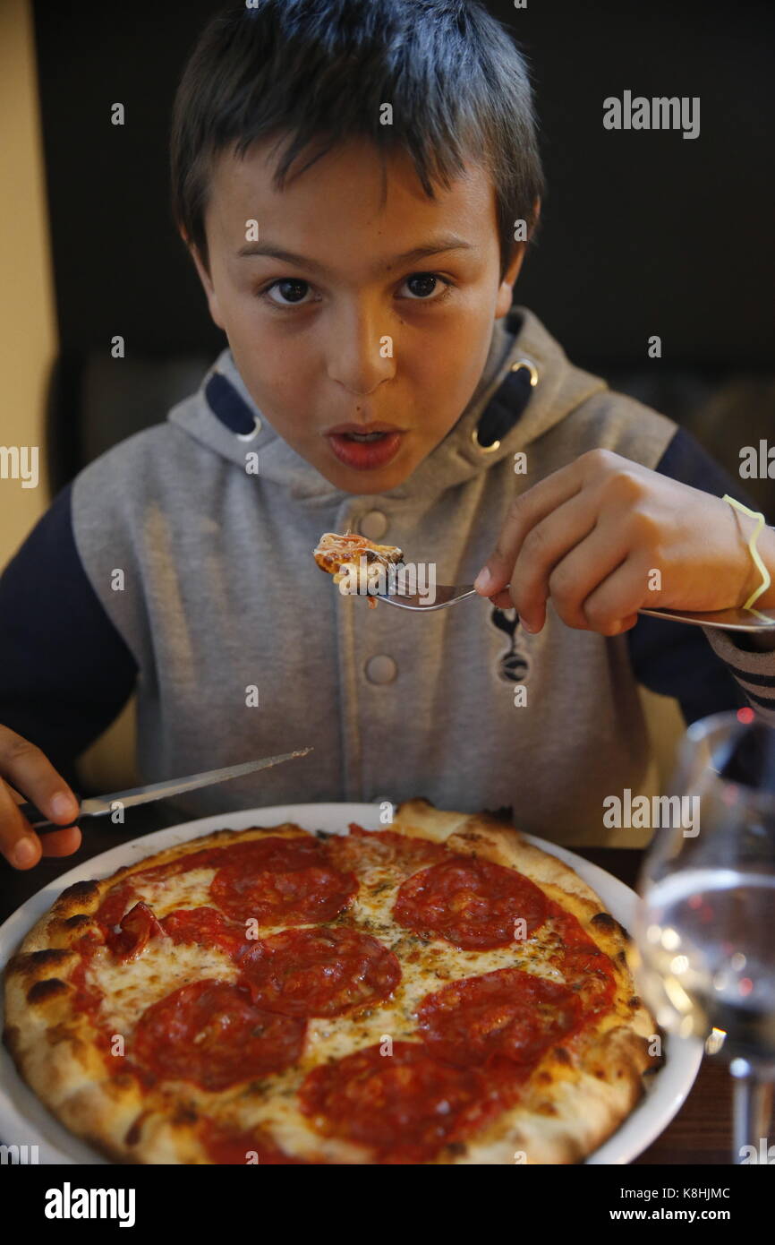 Boy eating pizza. france Stock Photo - Alamy