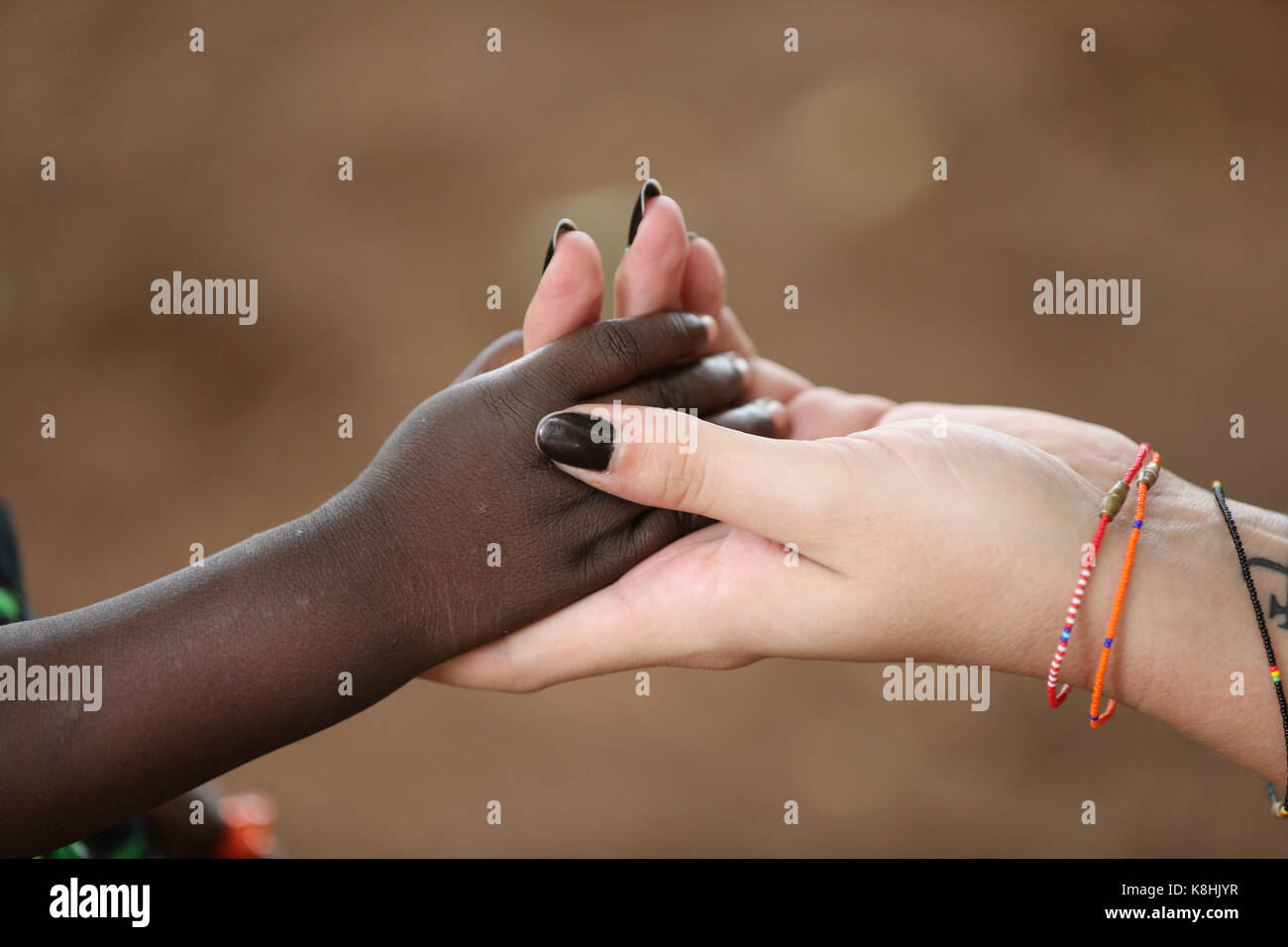 Humanitarian worker holding child's hand. togo Stock Photo - Alamy