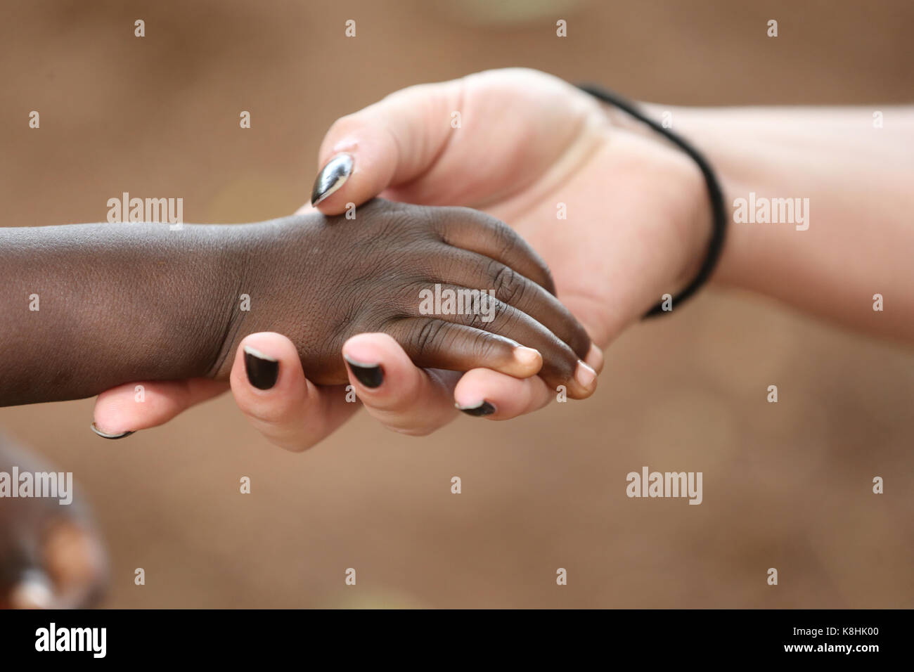 Humanitarian worker holding child's hand. togo Stock Photo - Alamy