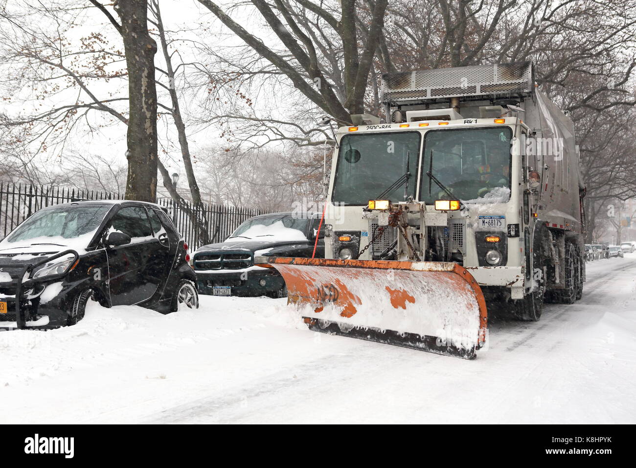 A garbage truck fitted with a snow plow clears snow during Winter Storm ...