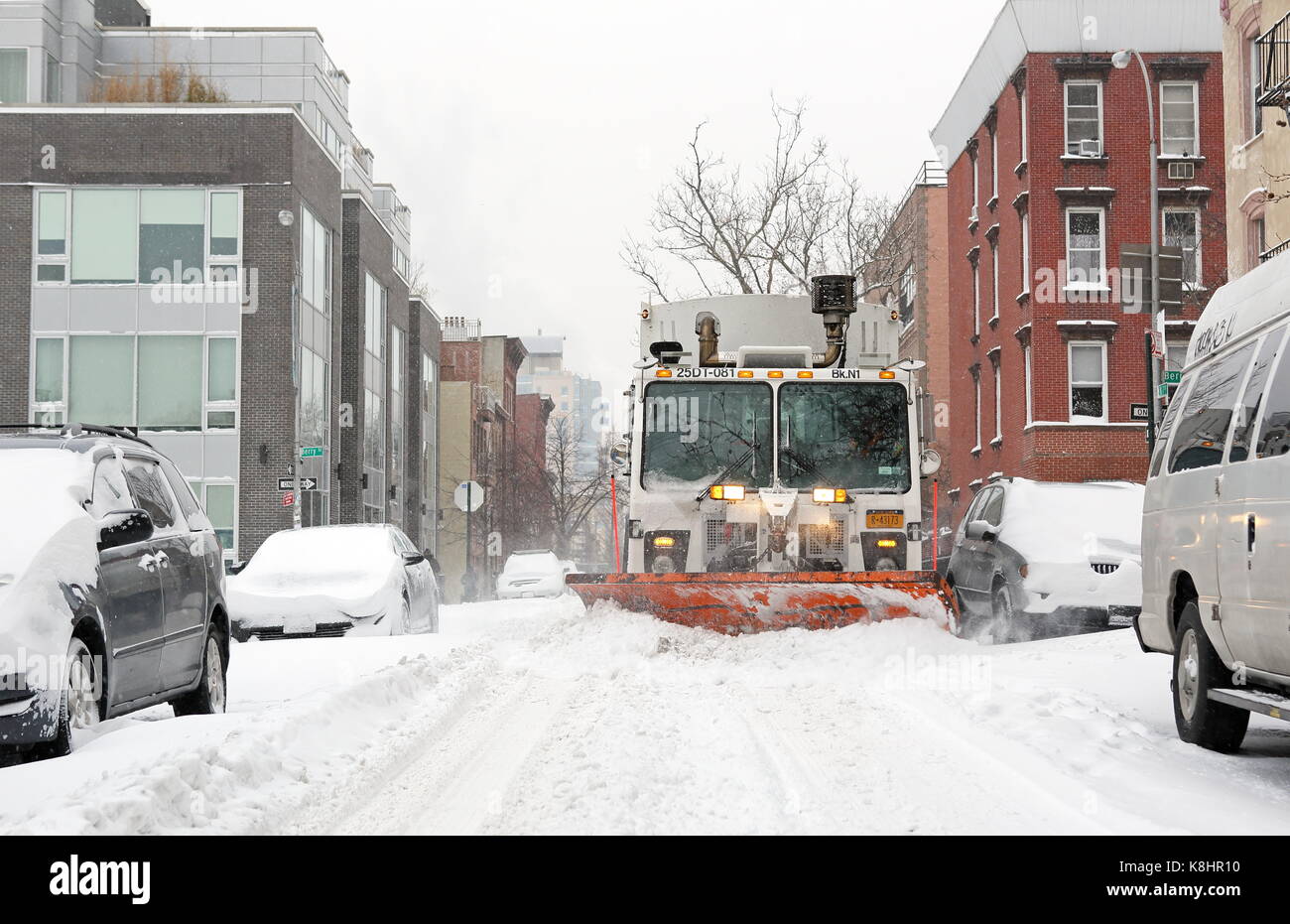 A garbage truck fitted with a snow plow clears snow during Winter Storm ...