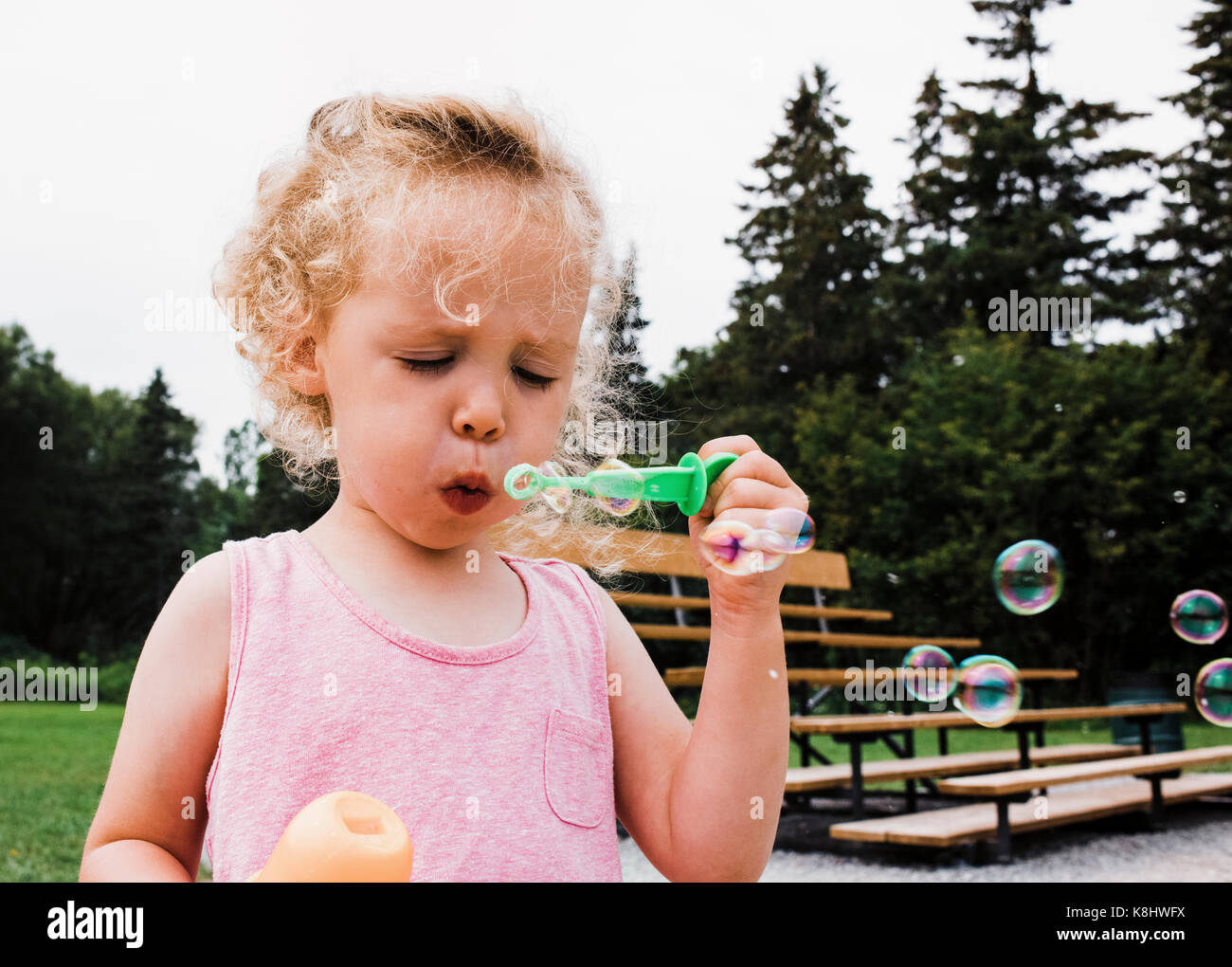 Cute girl blowing bubbles at playground Stock Photo - Alamy