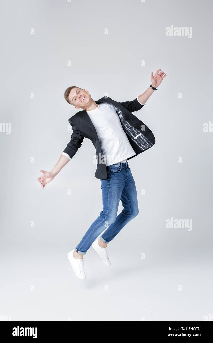 handsome man in jeans and jacket jumping Stock Photo - Alamy