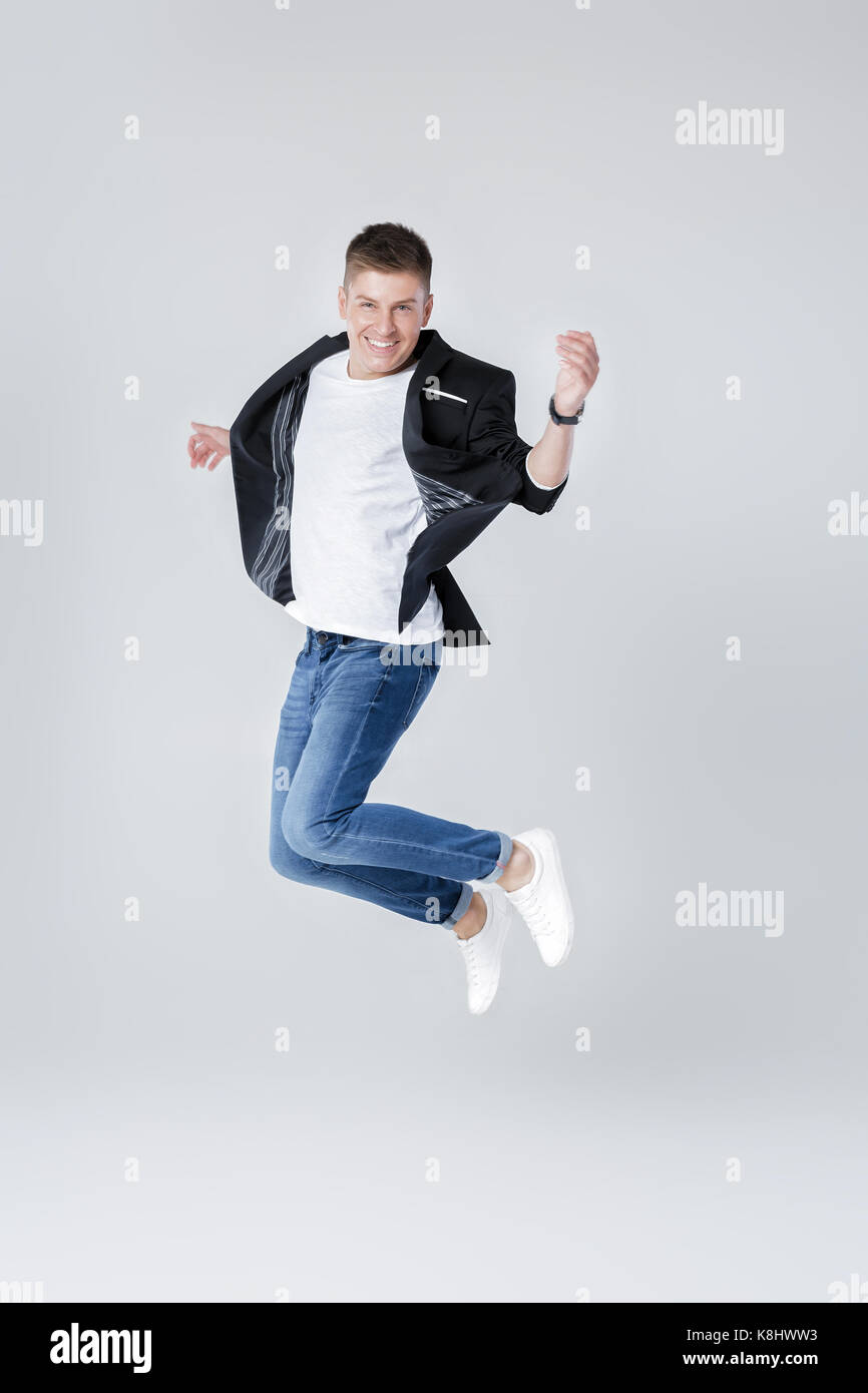 handsome man in jeans and jacket jumping Stock Photo - Alamy