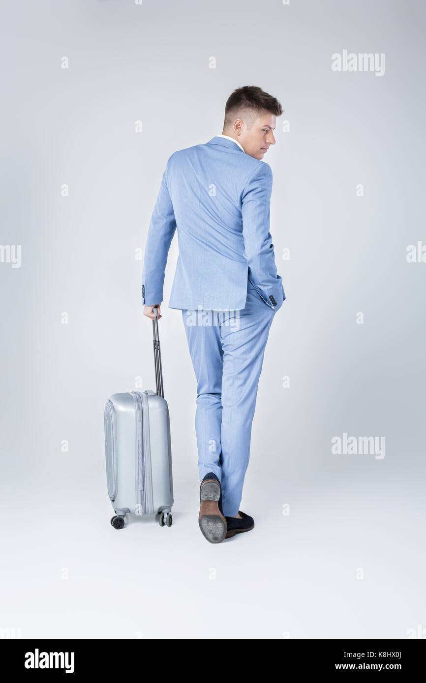 young man in blue suit with suitcase Stock Photo - Alamy