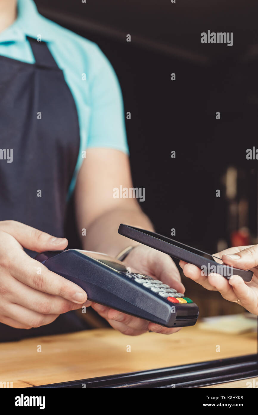 Person paying pay through smartphone using NFC Stock Photo - Alamy